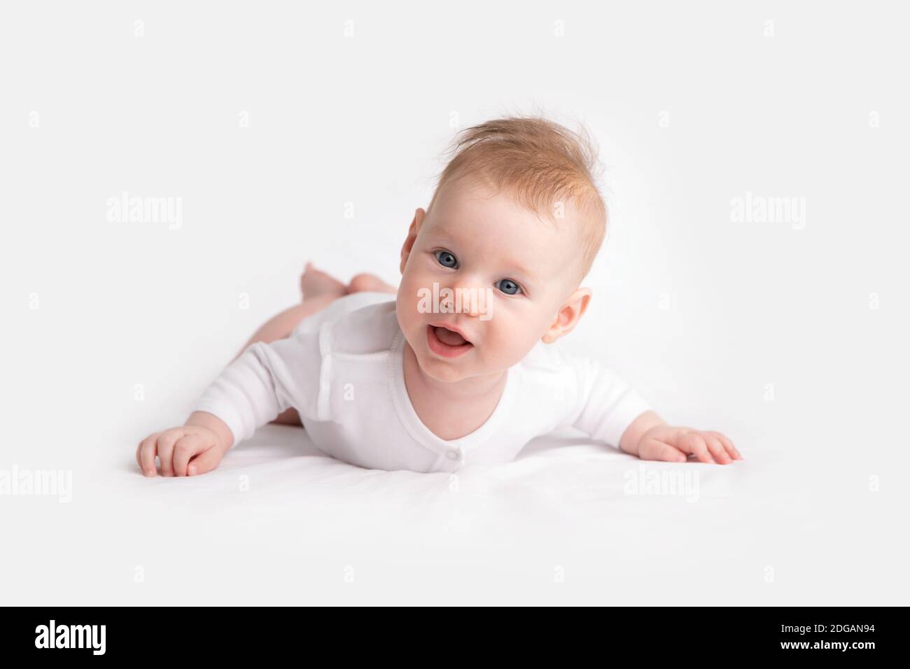 small baby in white clothes on light background Stock Photo - Alamy