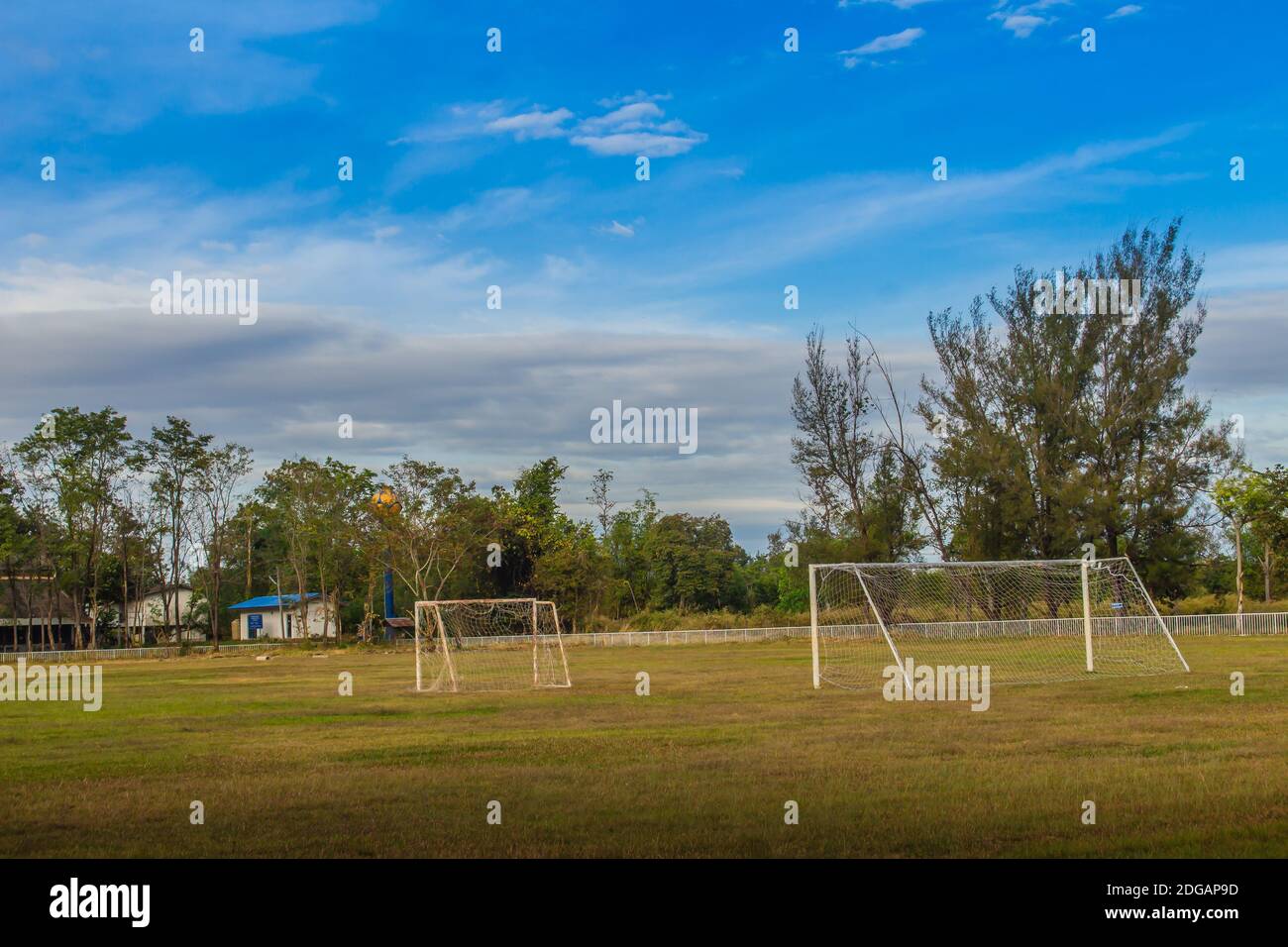 Local football stadium with goal post and blue sky and white clouds ...
