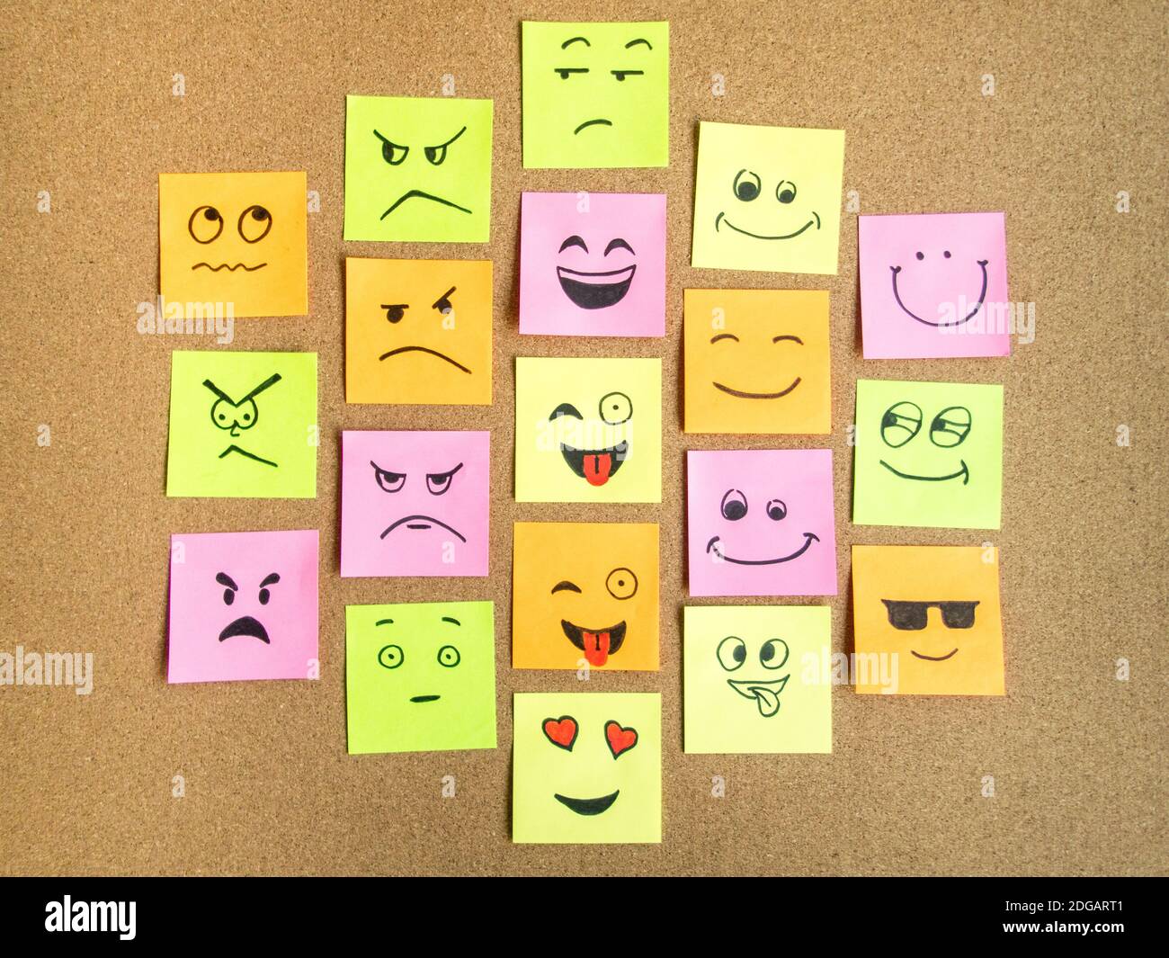 cork board with colorful post its representing various emoticons with ...