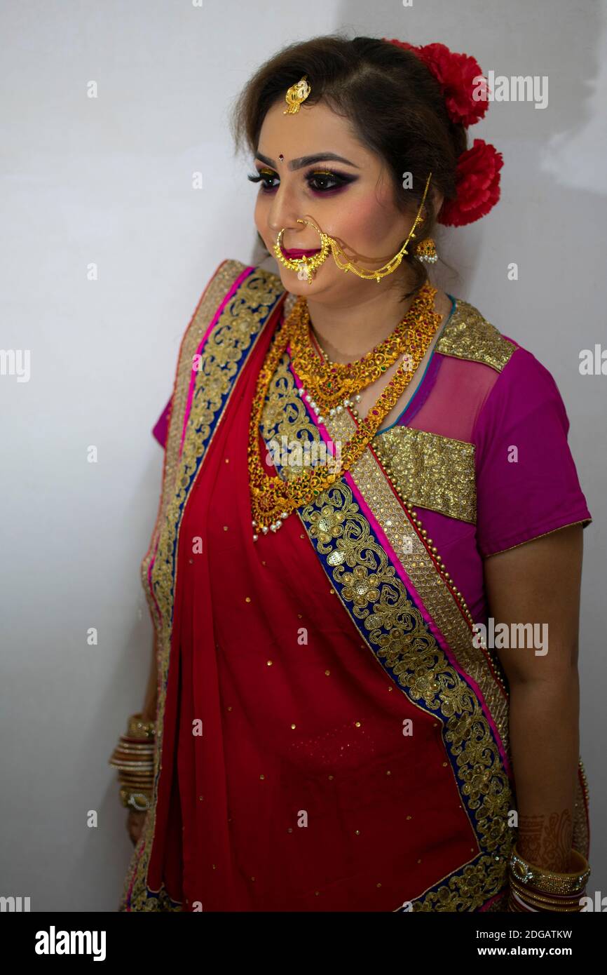 a beautiful Indian girl in bridal dress wearing red saree and gold ...