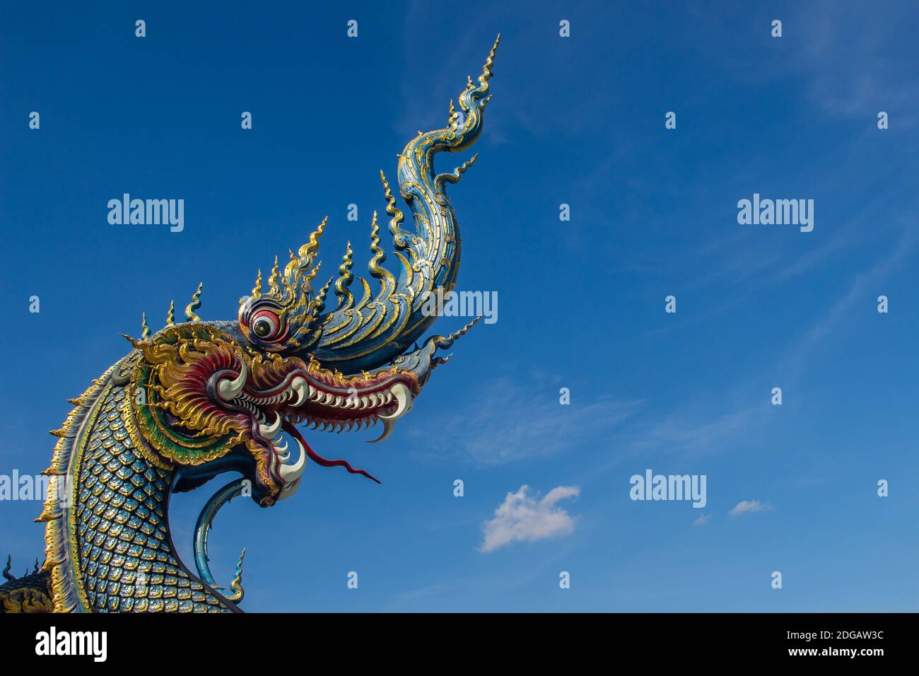 Beautiful blue naga sculpture with blue sky and white cloud on the ...