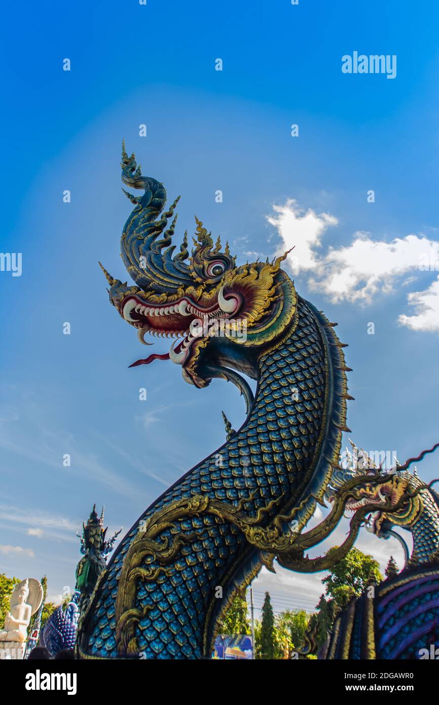 Beautiful blue naga sculpture with blue sky and white cloud on the ...
