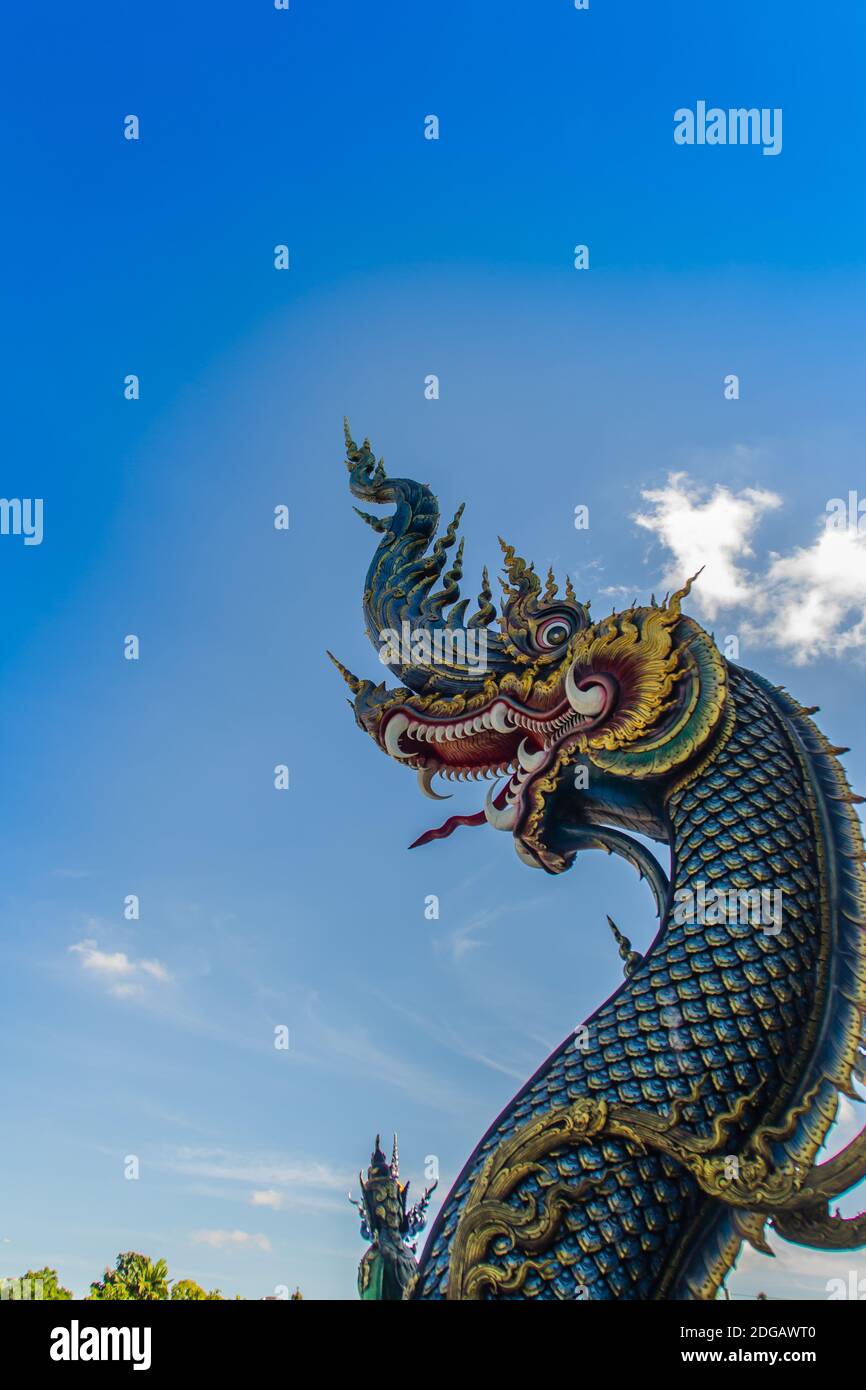 Beautiful blue naga sculpture with blue sky and white cloud on the ...