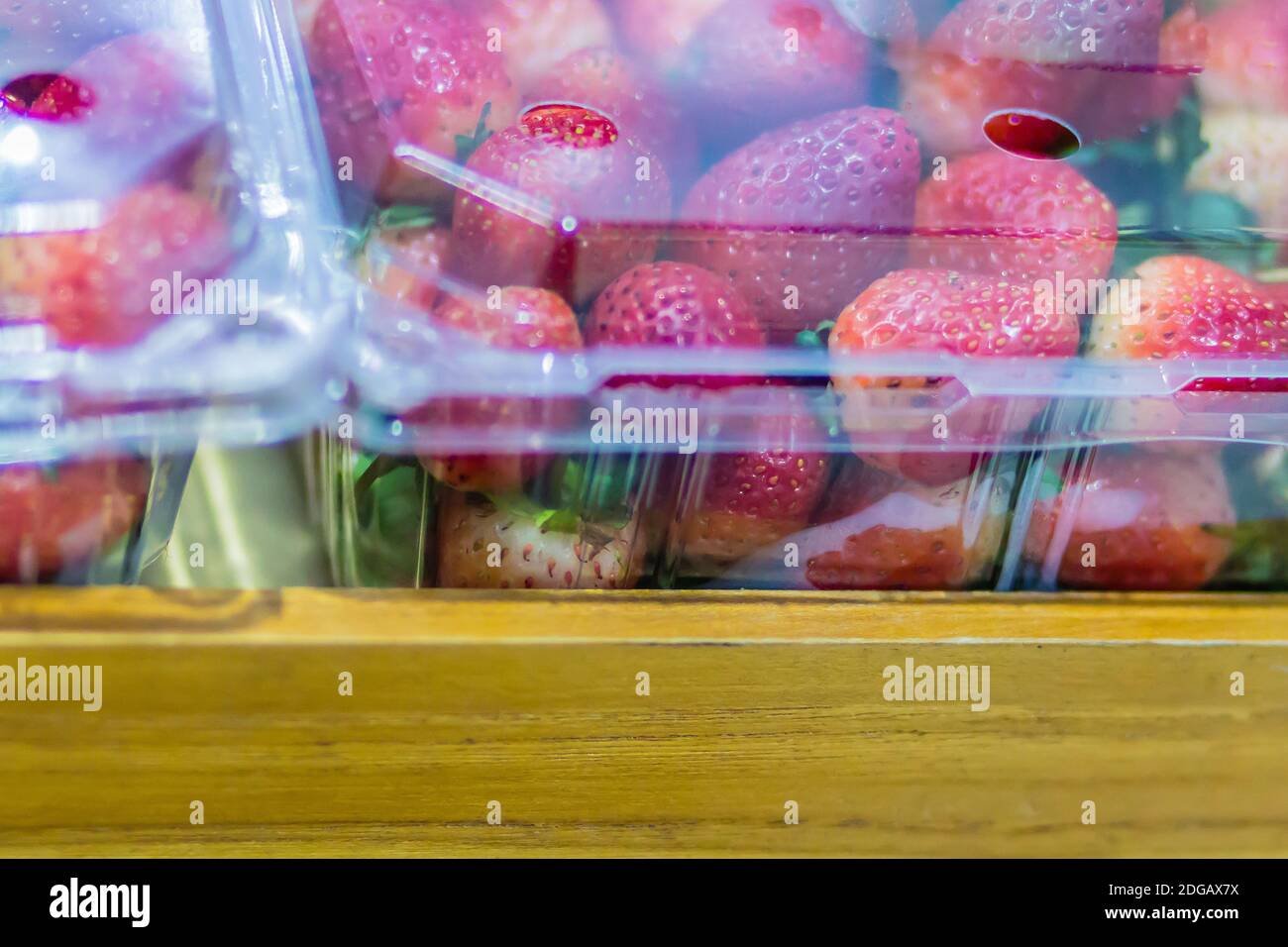 Fresh strawberries in plastic box package at the market. Red ripe ...