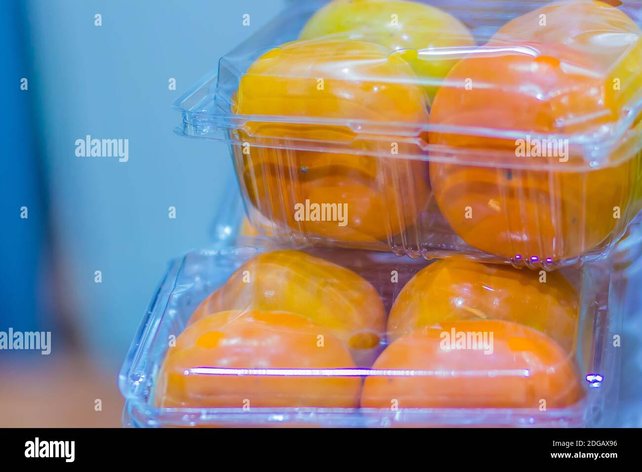 Ripe yellow Oriental or Japanese persimmons in transparent plastic box ...