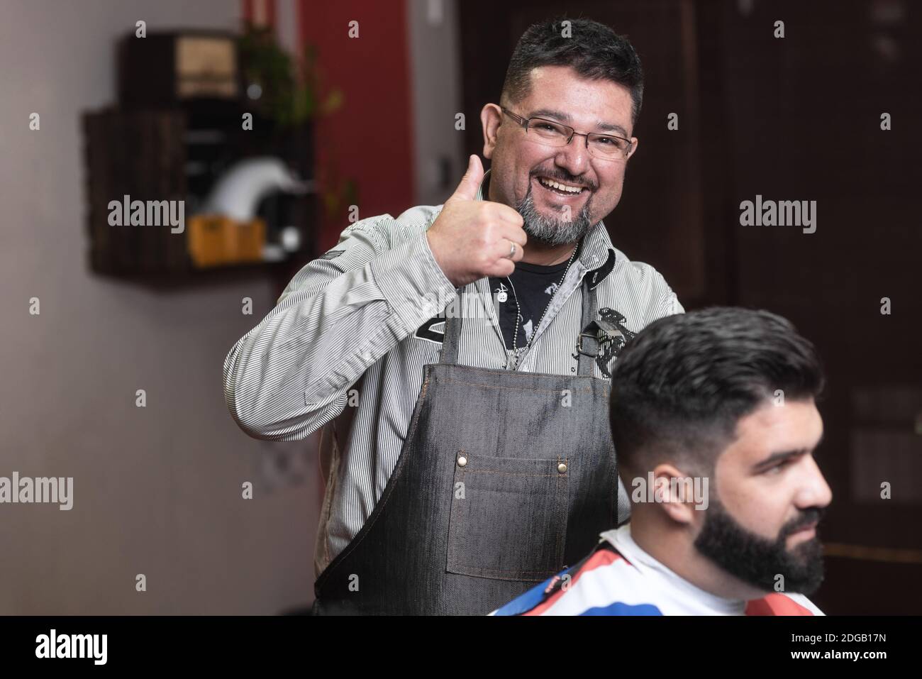 Happy barber customer satisfied with the result. Barber smiling showing ... Happy barber customer satisfied with the result. Barber smiling showing ...
