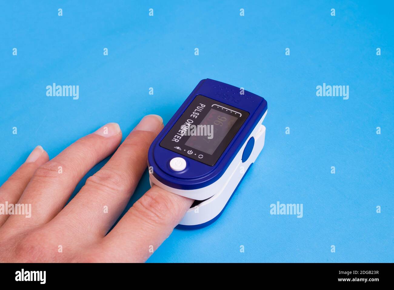 One pulse oximeter on finger on blue background close up Stock Photo ...