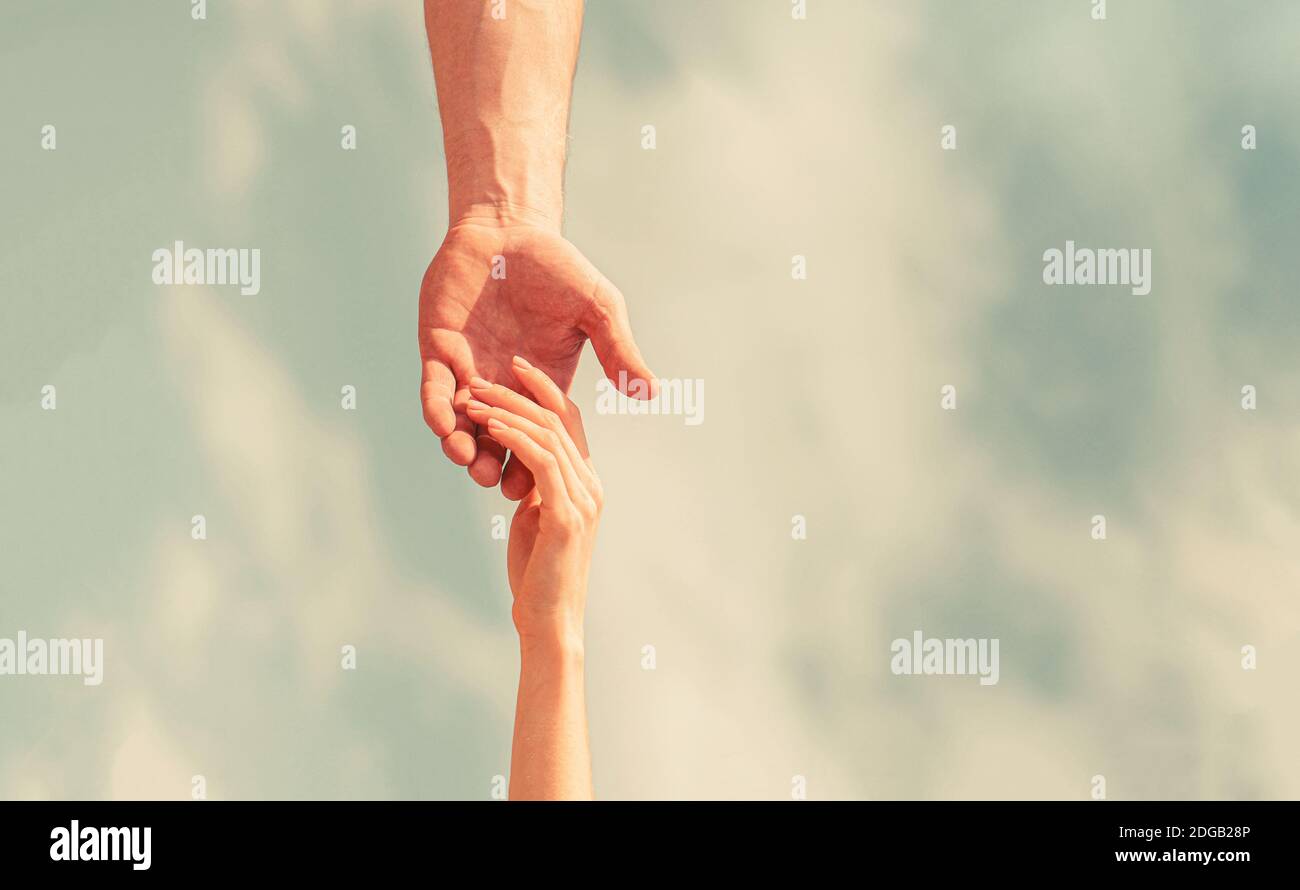 Giving a helping hand. Hands of man and woman on blue sky background ...
