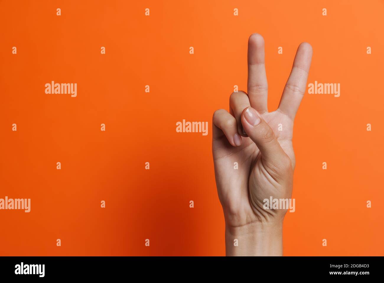 Woman hand showing two fingers on isolated background, peace gesture ...