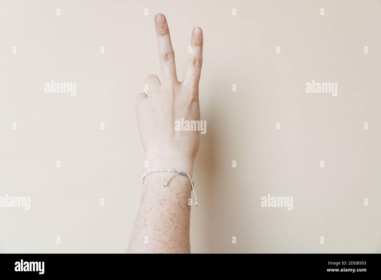 Woman hand showing two fingers on isolated background, peace gesture ...