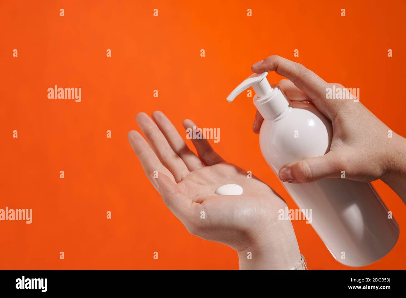 Woman's hands applying lotion isolated over background Stock Photo - Alamy