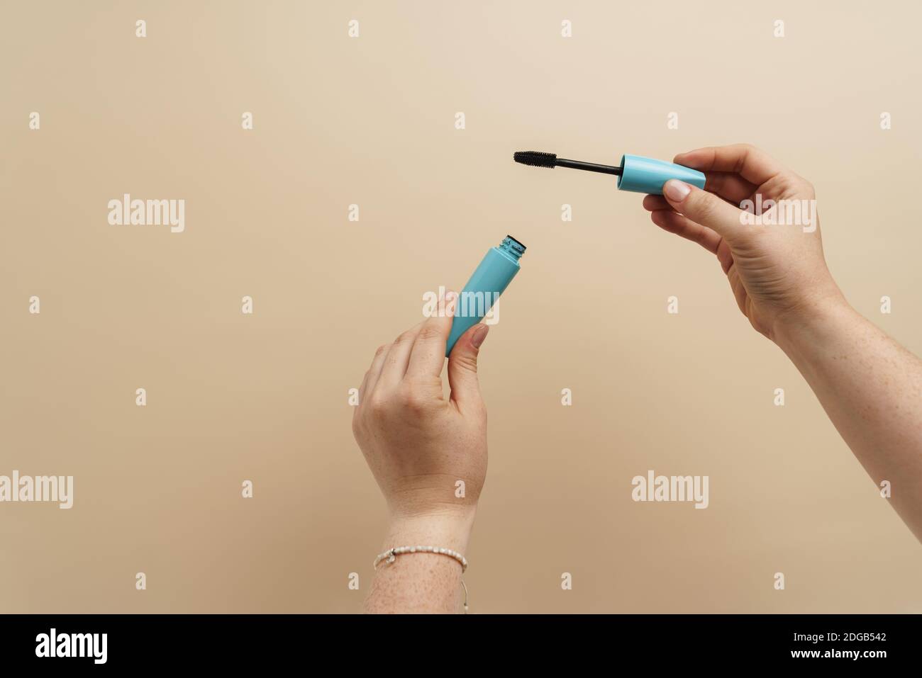 Woman's hand holding mascara isolated on background Stock Photo - Alamy