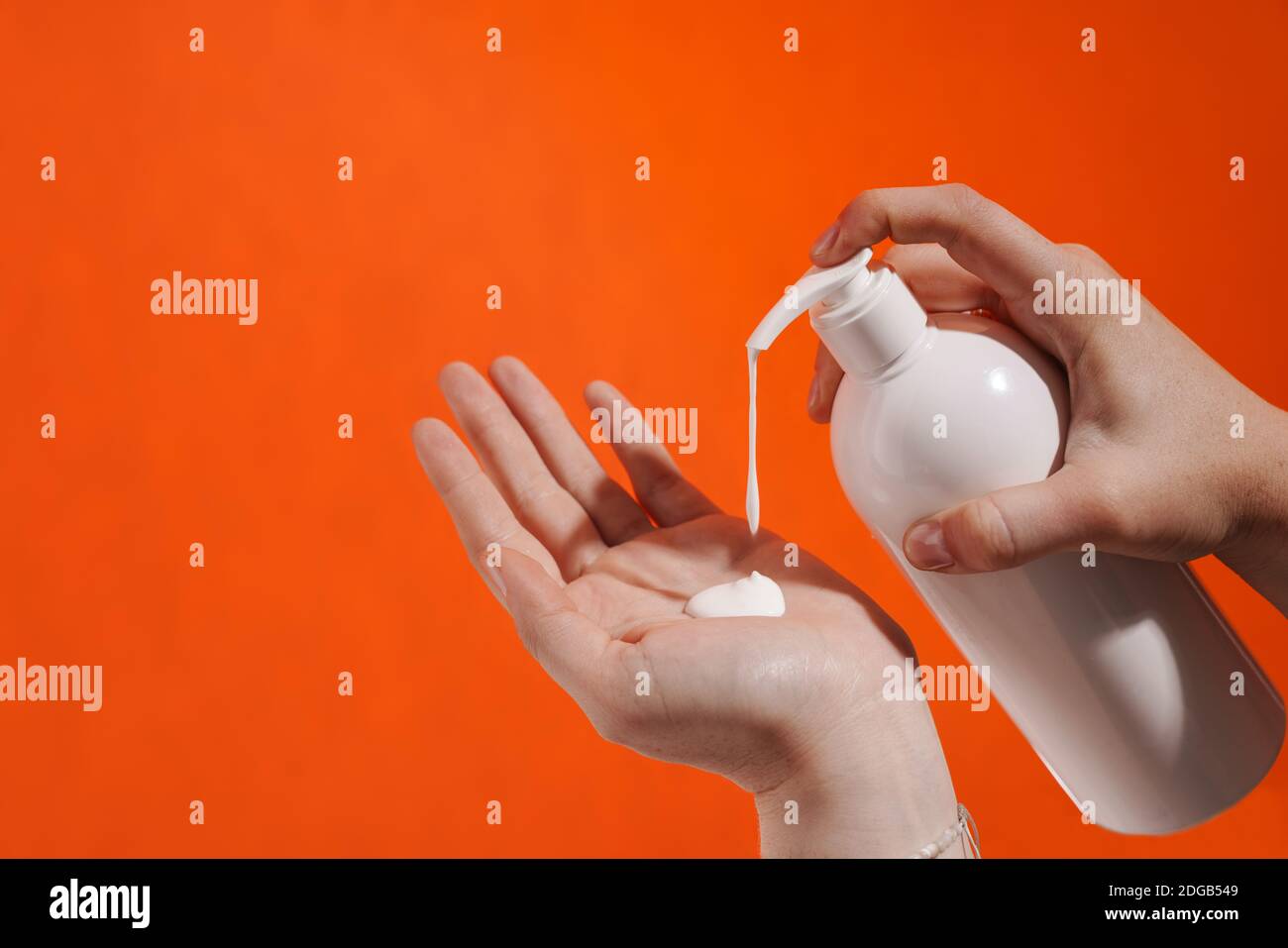 Woman's hands applying lotion isolated over background Stock Photo - Alamy