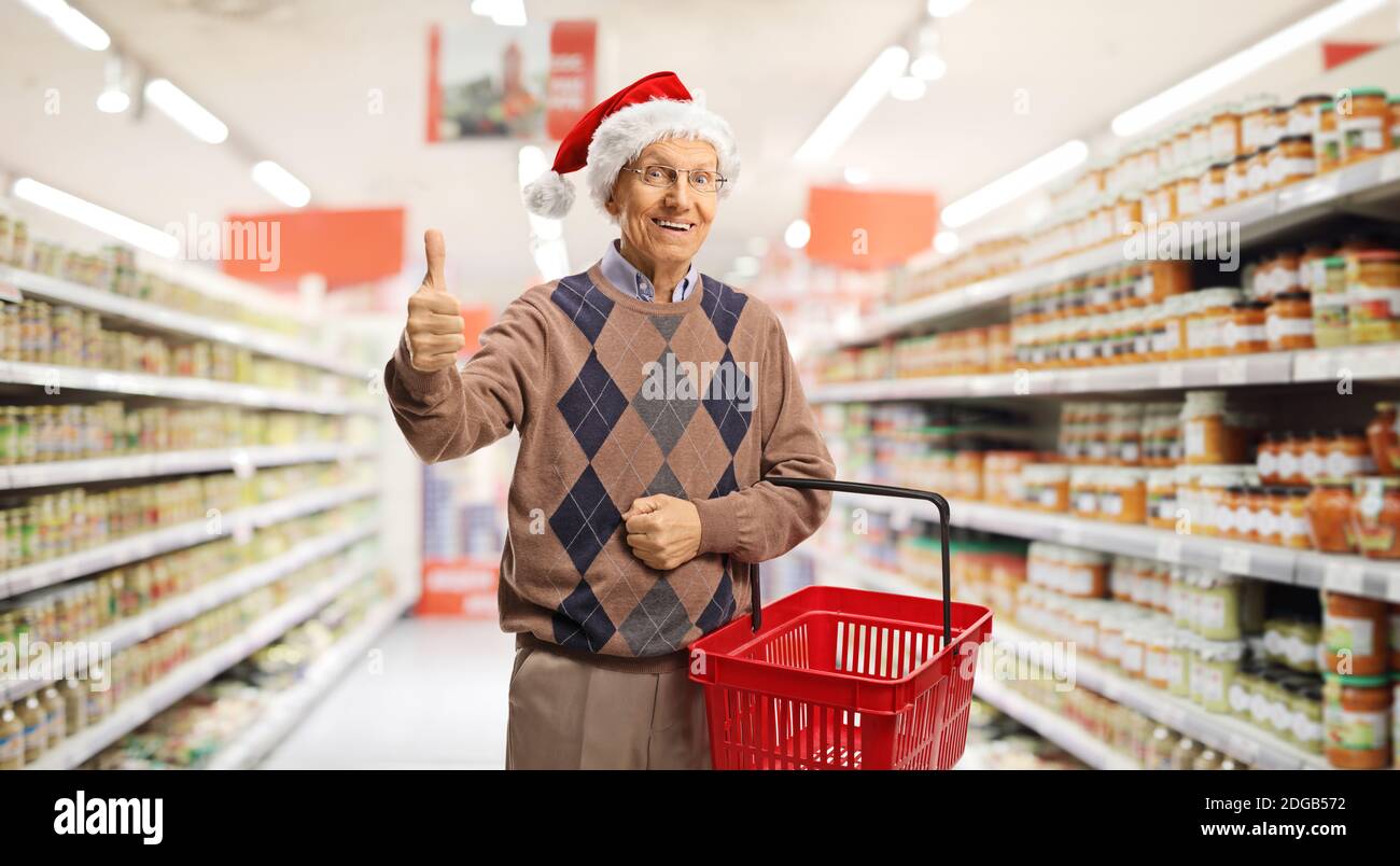 Elderly customer with a shopping basket in a supermarket showing a ...