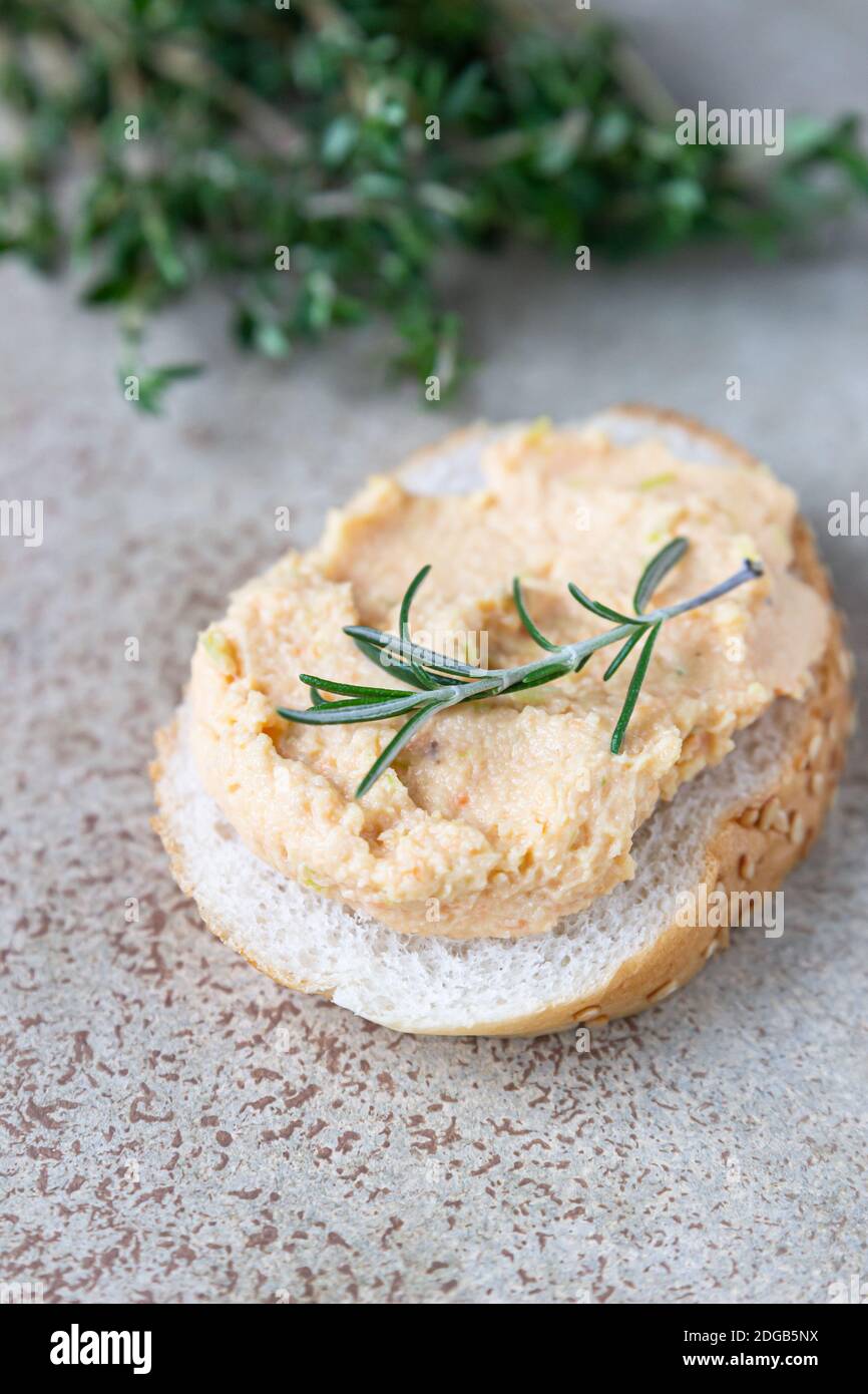 Homemade pate, spread or mousse on bread and herbs, light concrete ...