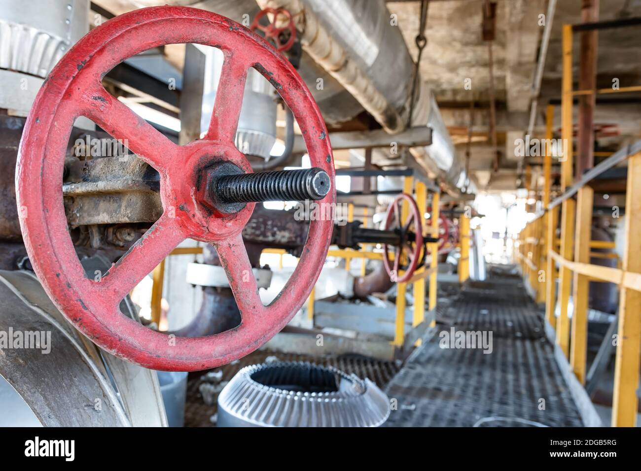 Worn steel catch in the workshop of a refinery with a red valve Stock ...