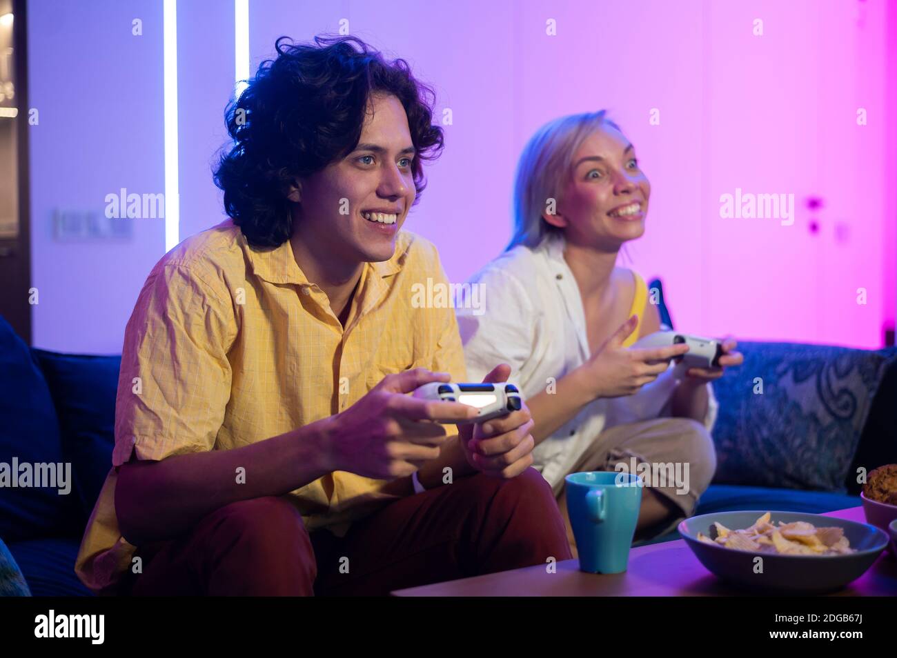 Happy boyfriend and girlfriend playing video games and holding ...