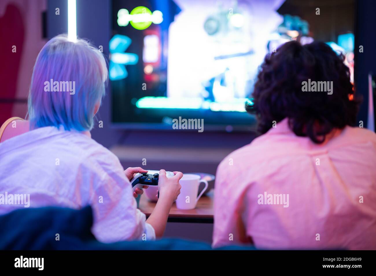 Happy couple playing video games at home during self isolation on a ...