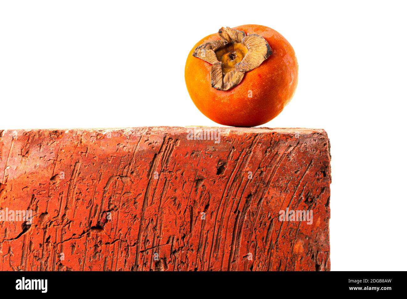 ripe persimmons on red brick isolated on white Stock Photo - Alamy