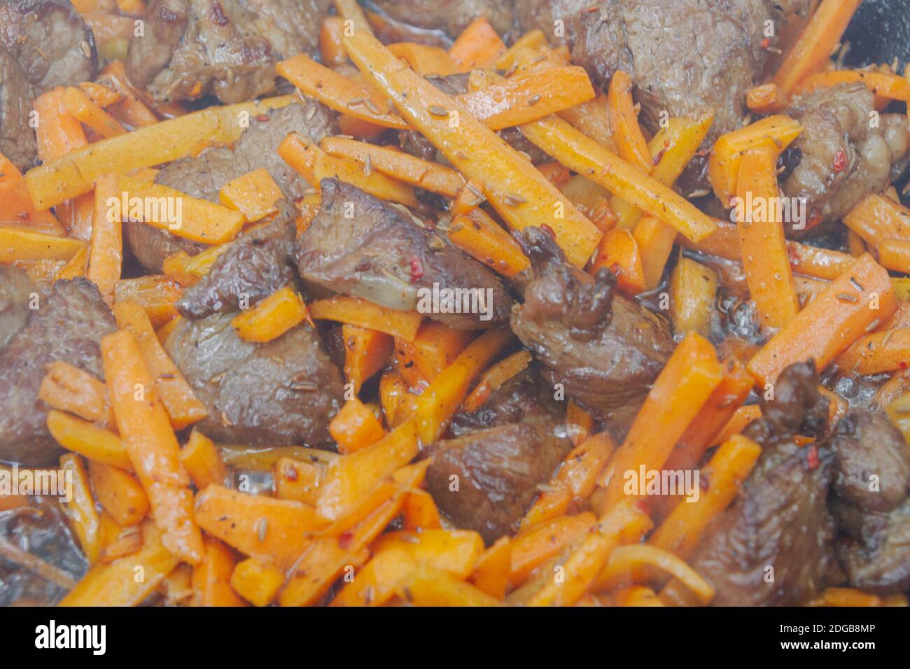 Cooking pilaf in a cauldron on the grill outside in the summer Stock ...