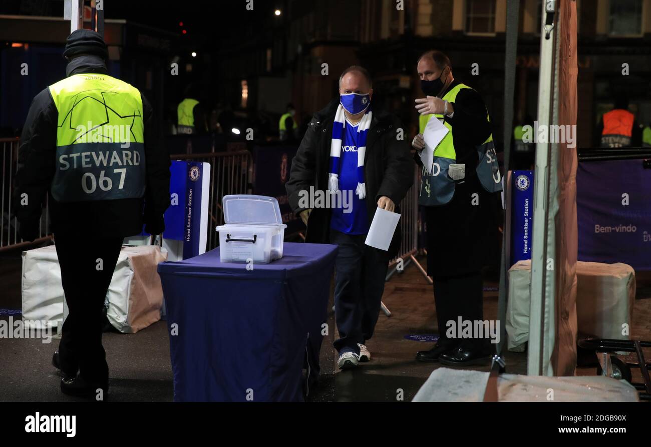 A Chelsea fan arrives through a checkpoint wearing a face mask before ...