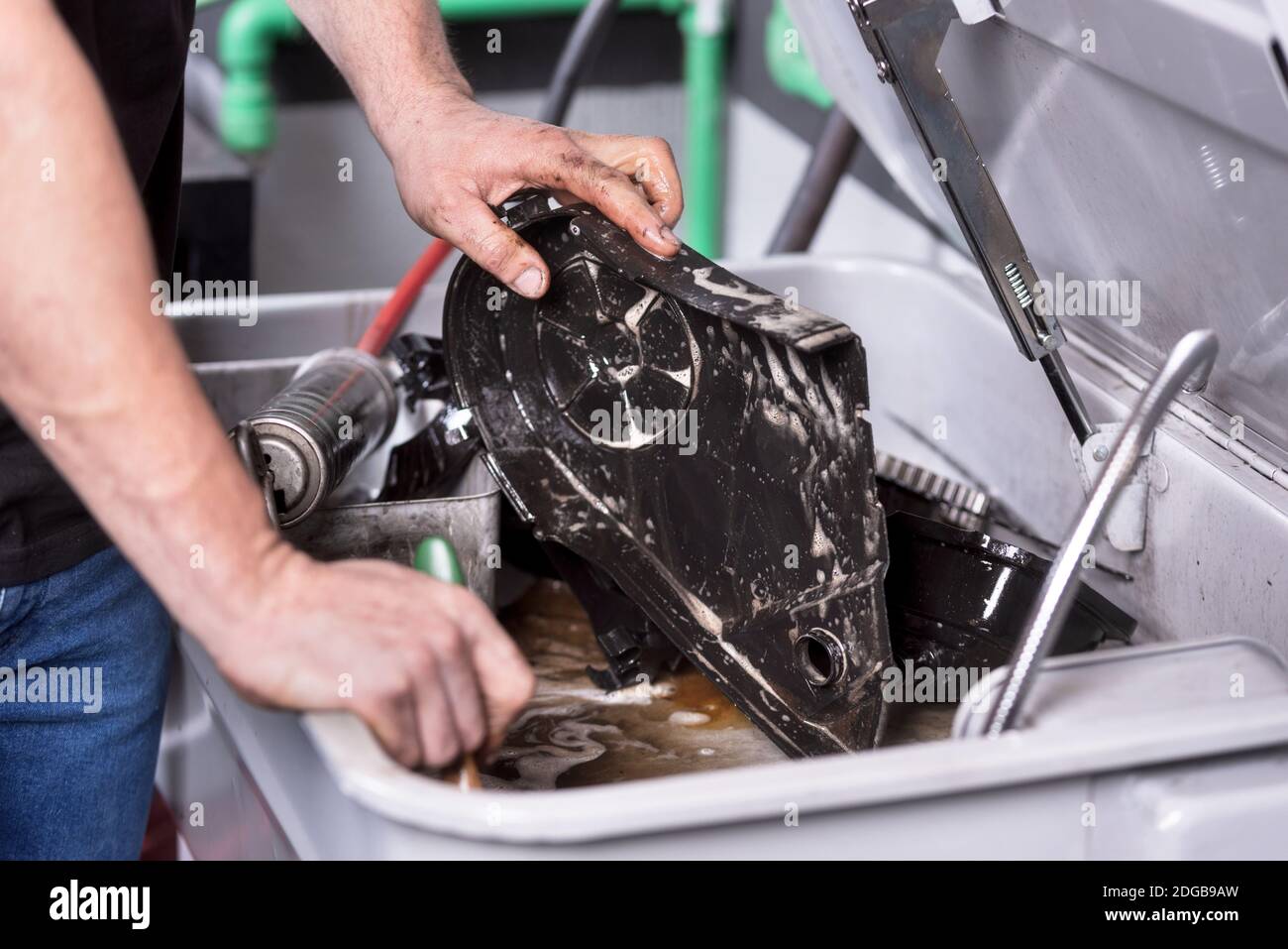 Mechanic degreasing a car engine part at service repair station Stock ...