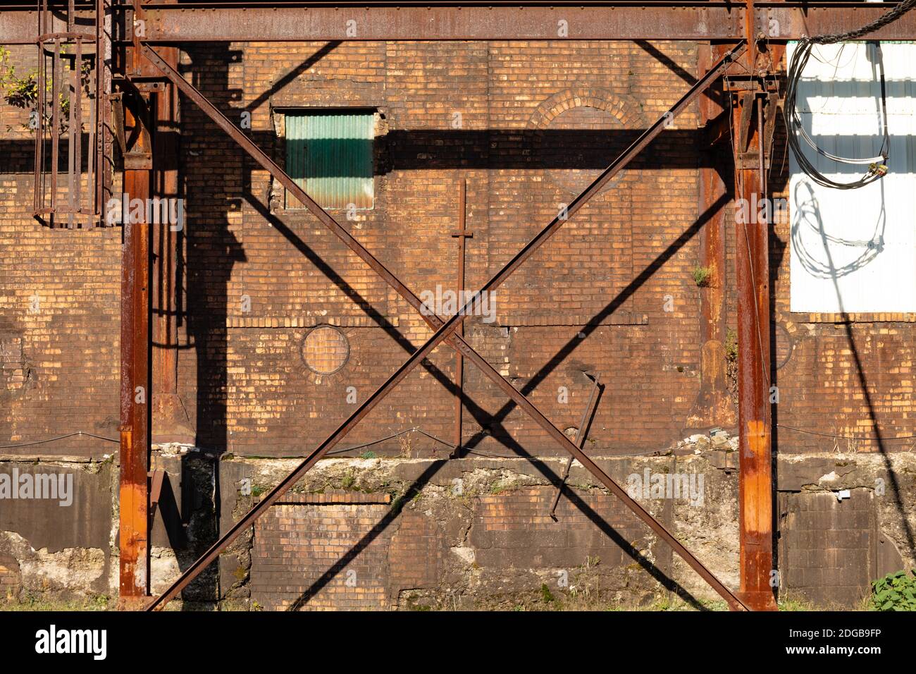 Industrial building exterior, orange brick behind heavy metal structure ...
