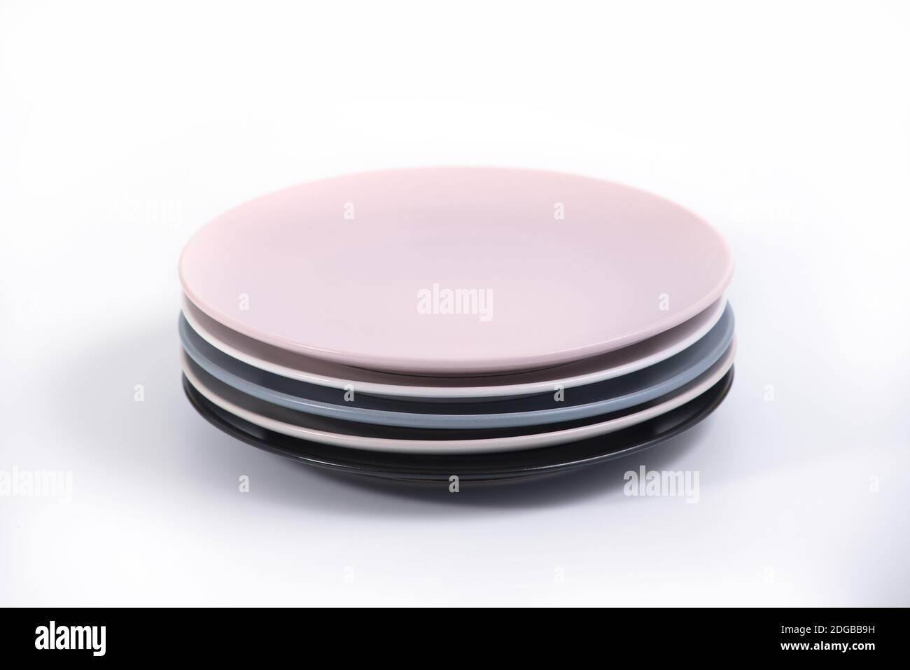 Stack of five colorful empty plates isolated on white background, side ...