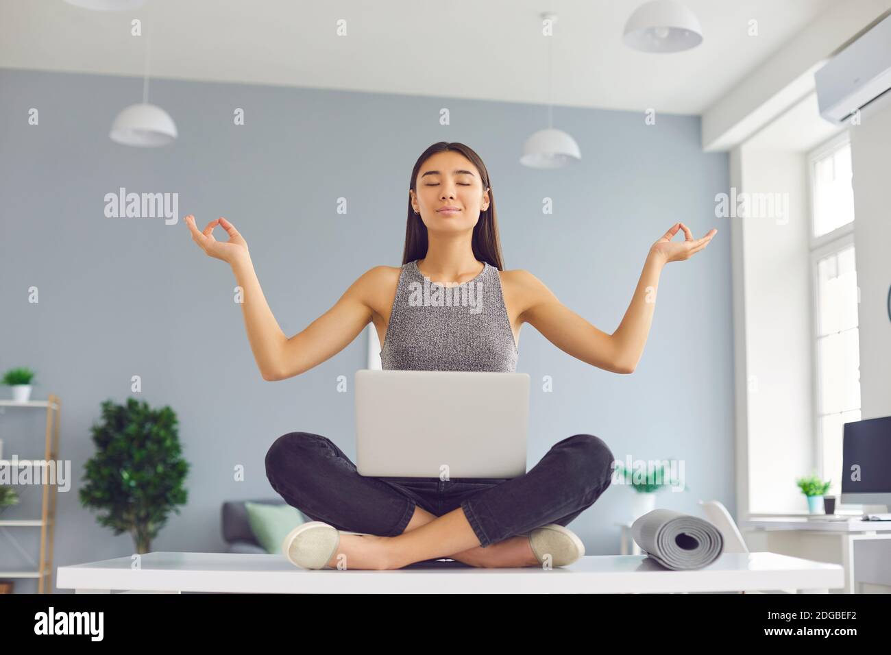 Office worker with positive mindset sitting on desk in easy pose ...