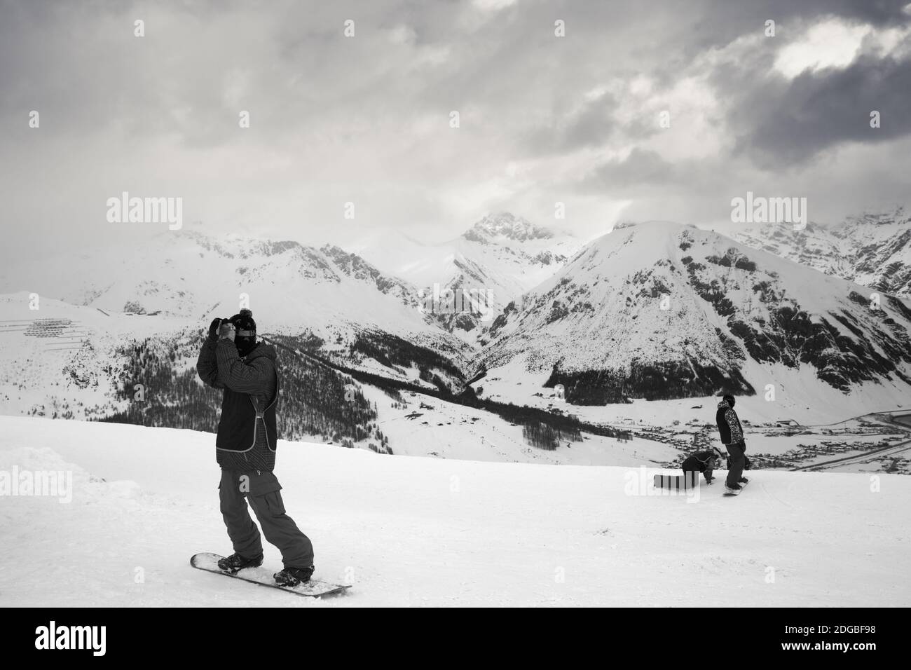 Group of snowboarders starts on off-piste descent. High snowy mountains ...