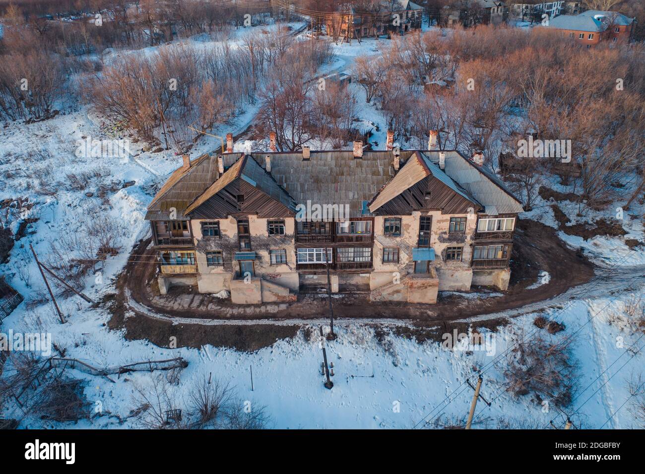 Snow covered old poor house, road and tree in russian city, frozen ...