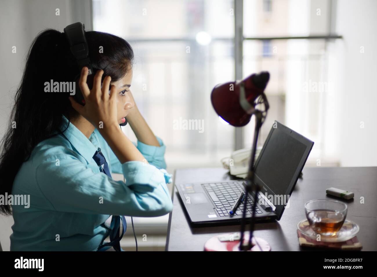 An Indian Bengali brunette young woman/telecaller in office wear is ...
