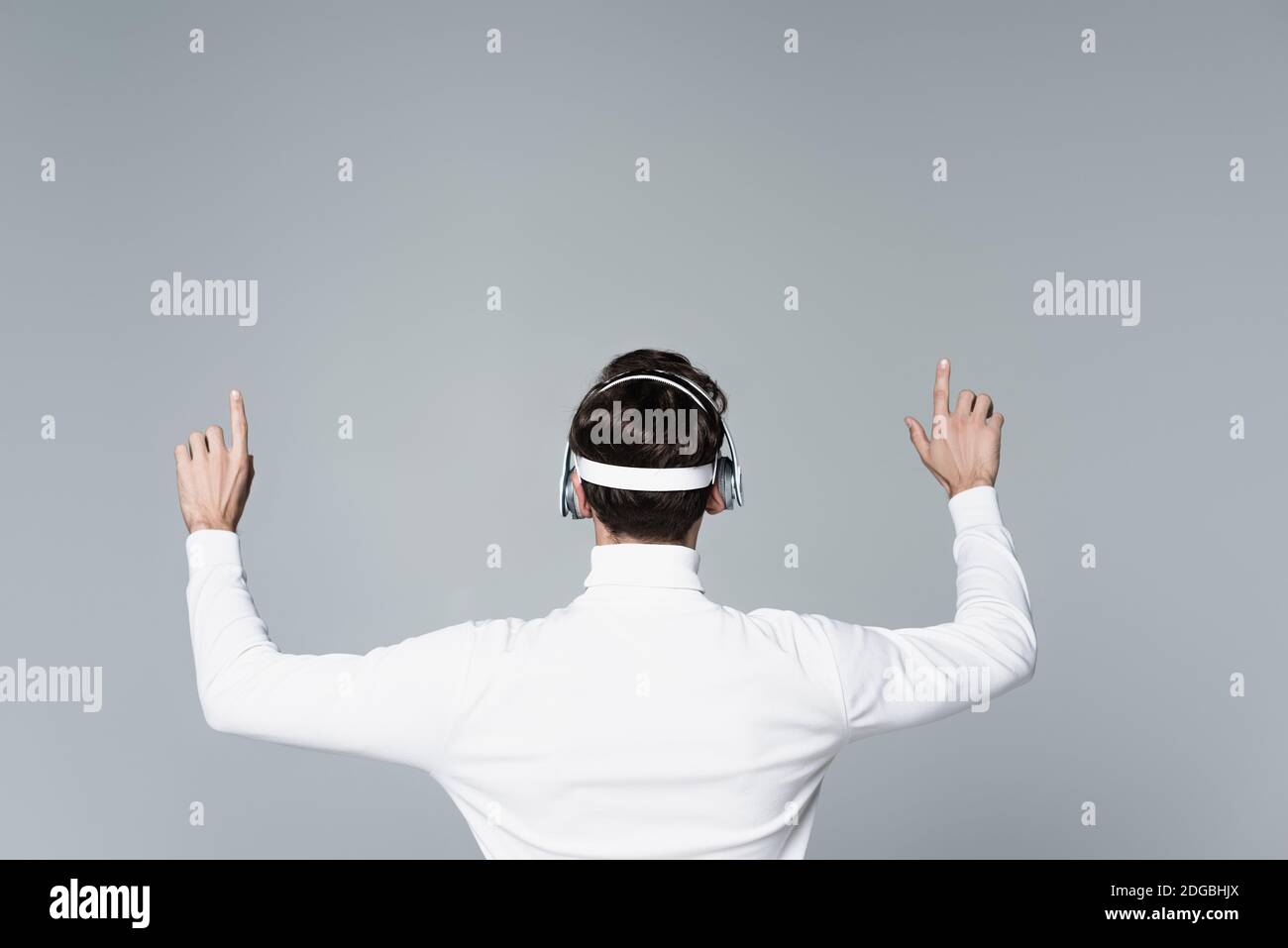 Back view of cyborg in headphones using something isolated on grey ...