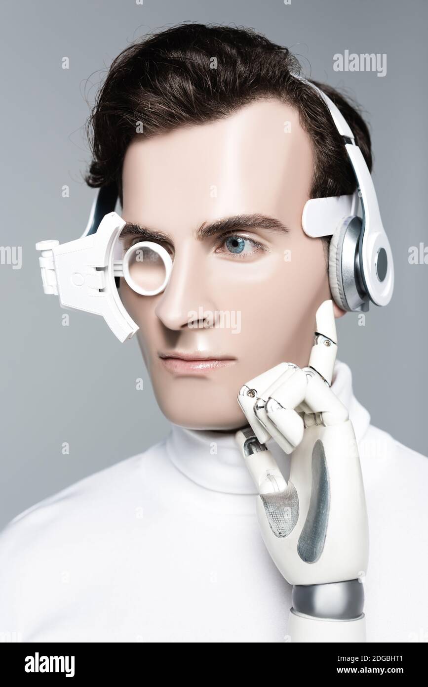 Cyborg man in digital eye lens, headphones and artificial hand looking ...