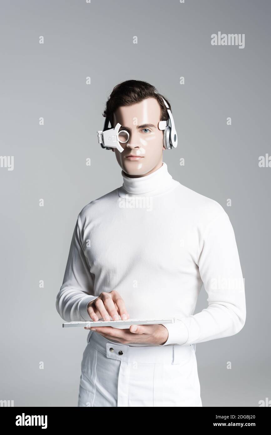 Cyborg in headphones and digital eye lens holding computer keyboard and ...