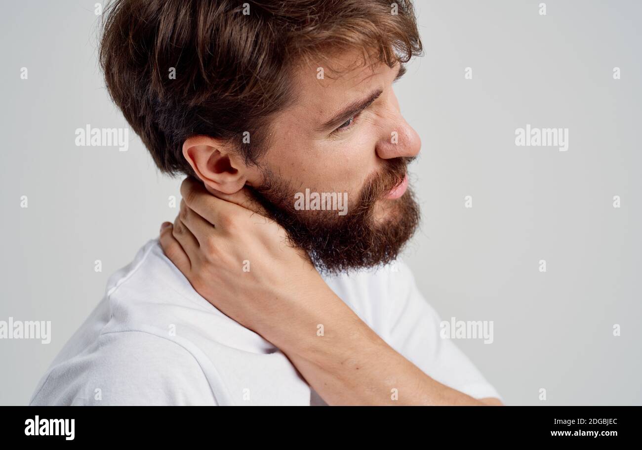 young man touching neck with hands spine pain side view model portrait ...