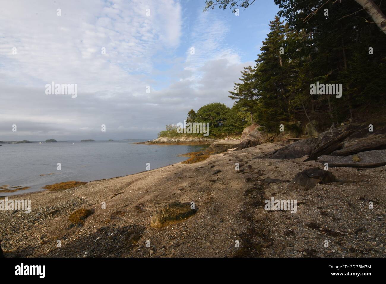 Rock covered beach along the shoreline of an island on the coast of ...