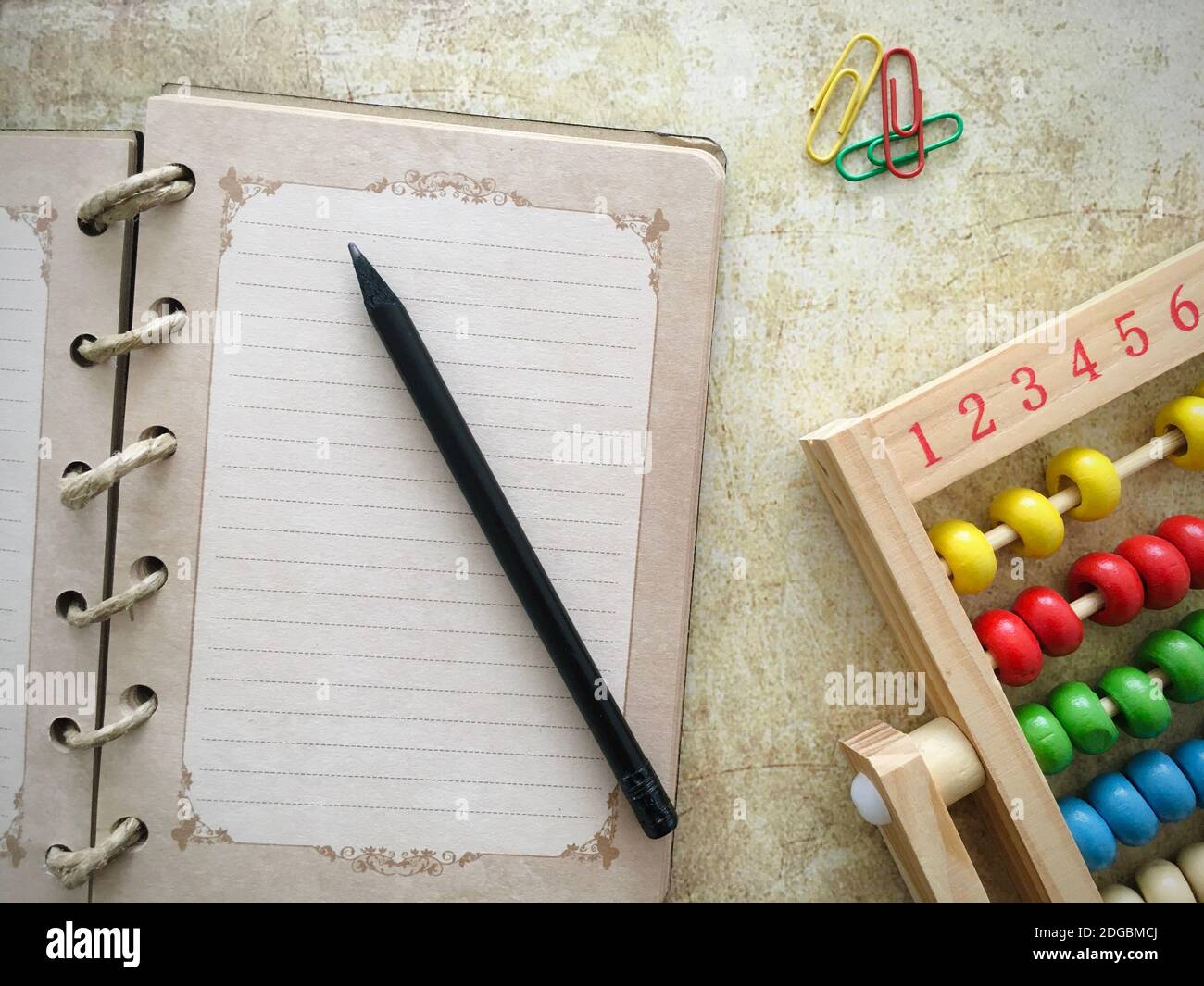 Overhead view of an open notebook with pencil next to an abacus Stock ...