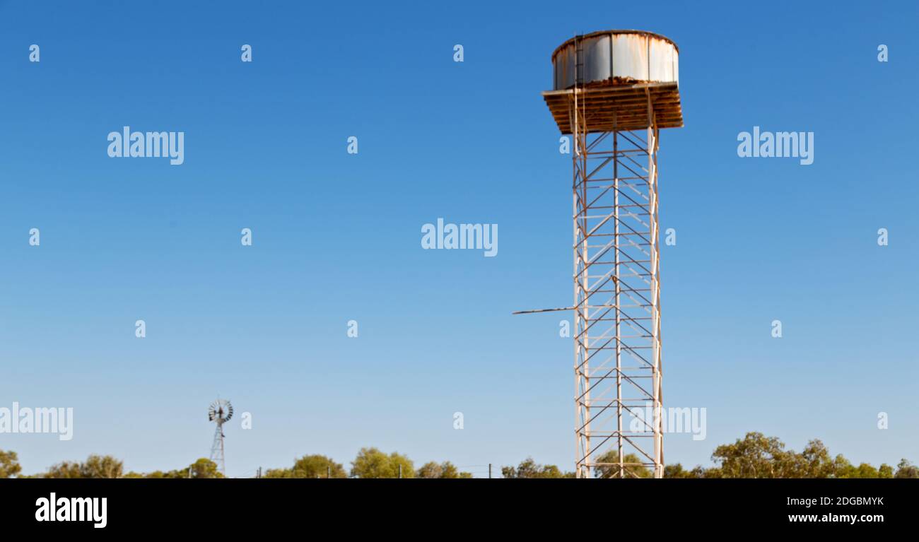 In the outback with asphalt line and water tank Stock Photo - Alamy