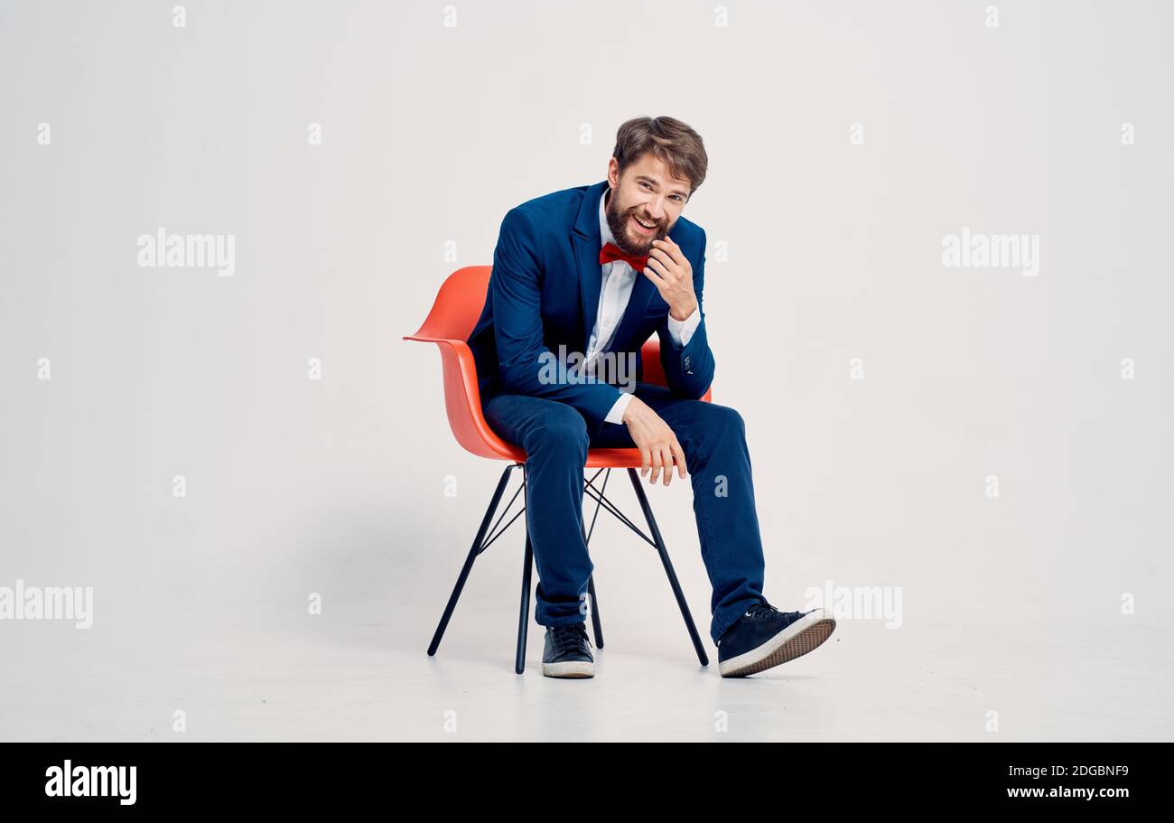 business man in suit sitting on red chair official Stock Photo - Alamy
