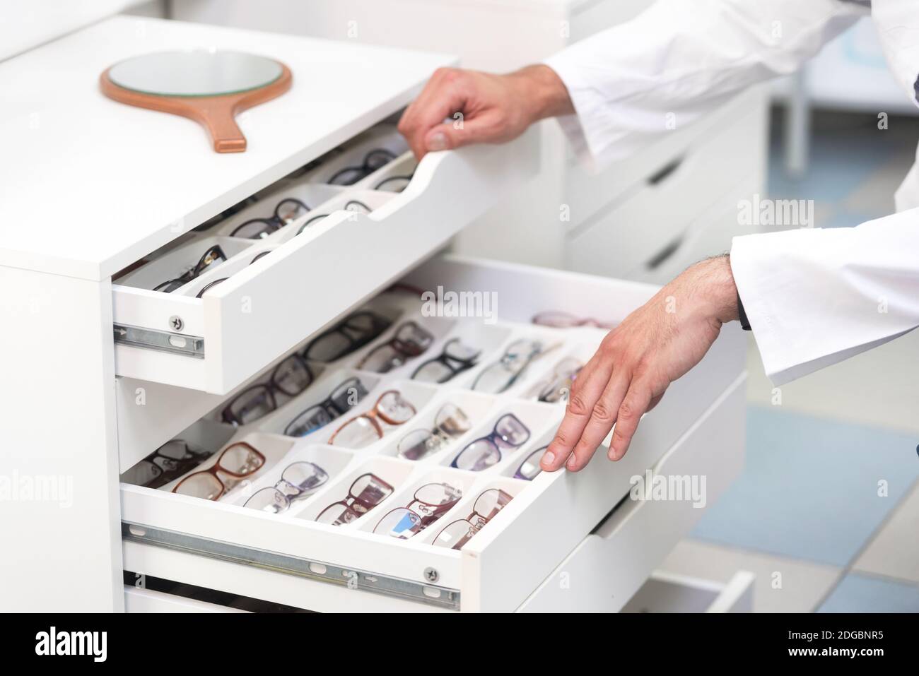 Ophthalmologist hands close up, choosing glasses from a drawer in the ...