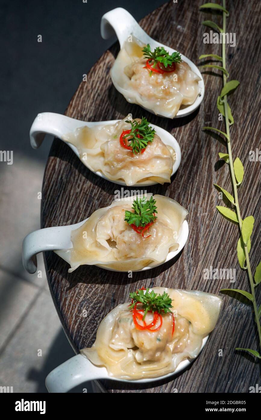 Four chicken dumpling appetizers on spoons Stock Photo - Alamy