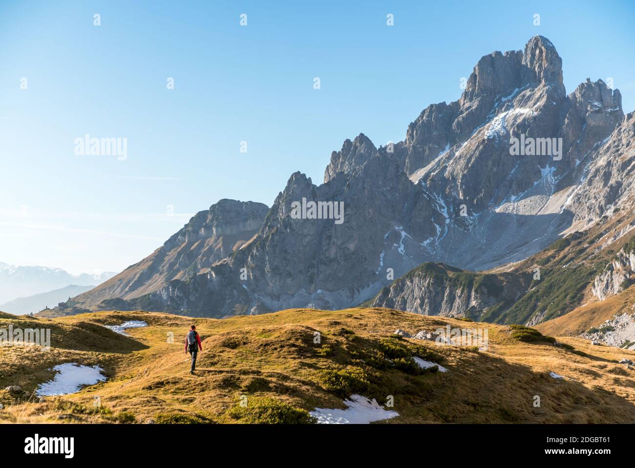 Woman hiking on footpath in alpine landscape in spring, Filzmoos ...