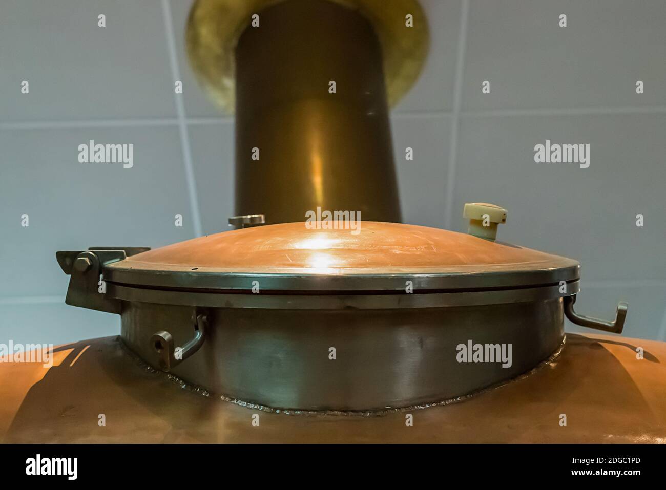 Copper hatch on a large tank on the background of a pipe leaving the ...