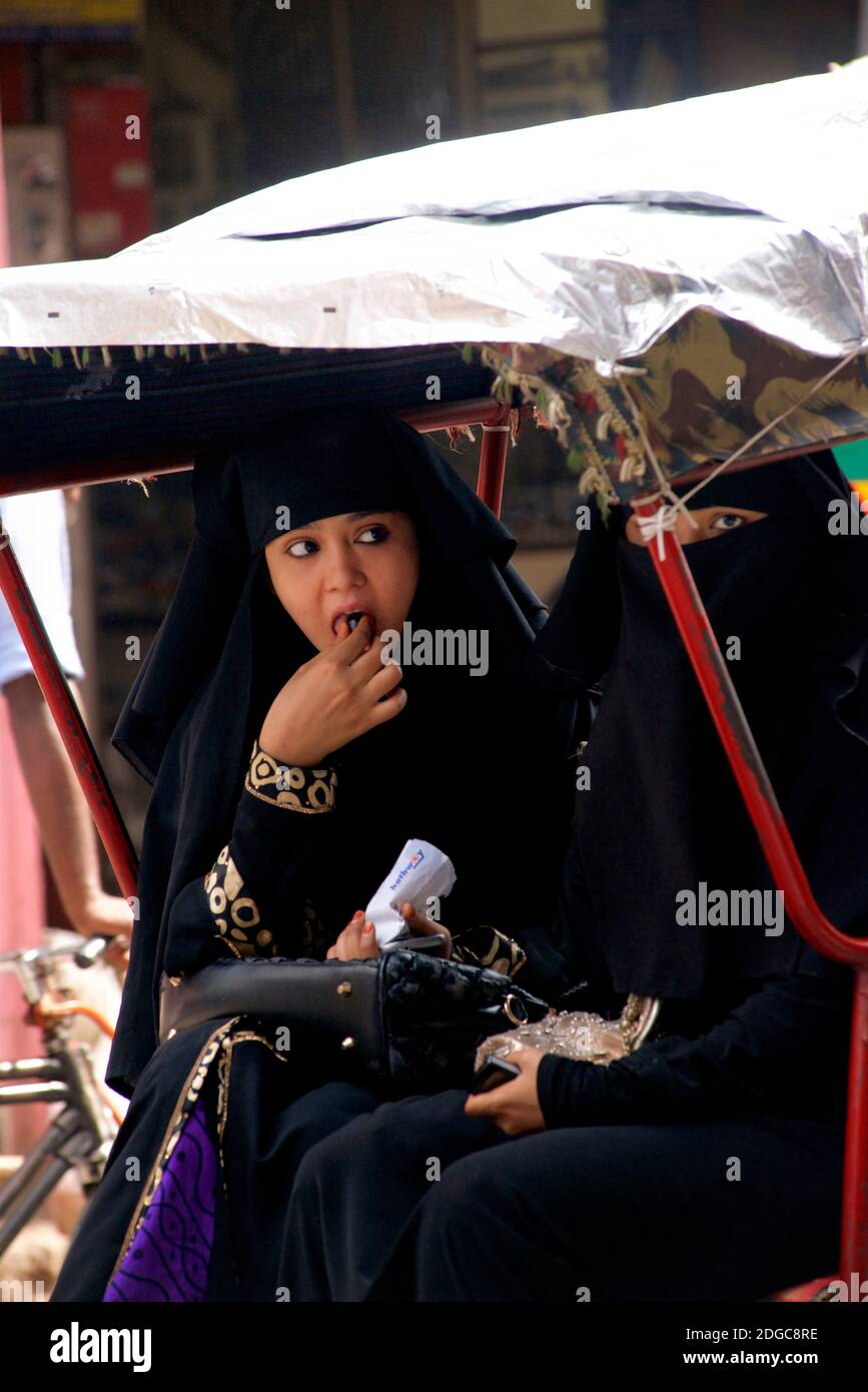 Muslim women in black islamic attire riding in a rickshaw, Chandi Chowk ...