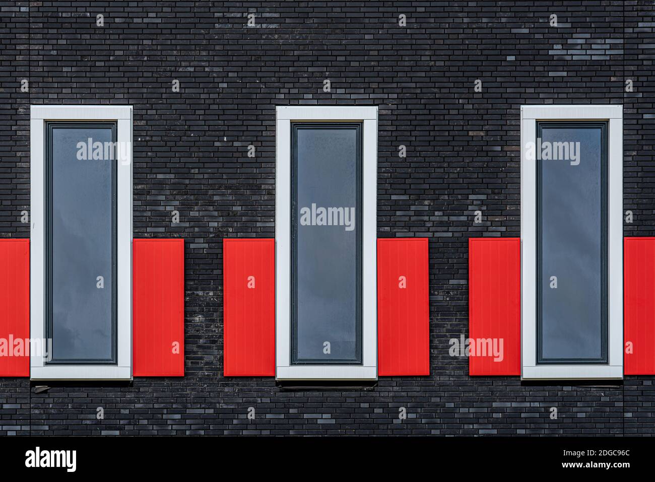 A fragment of a modern building brick facade with three windows in a ...