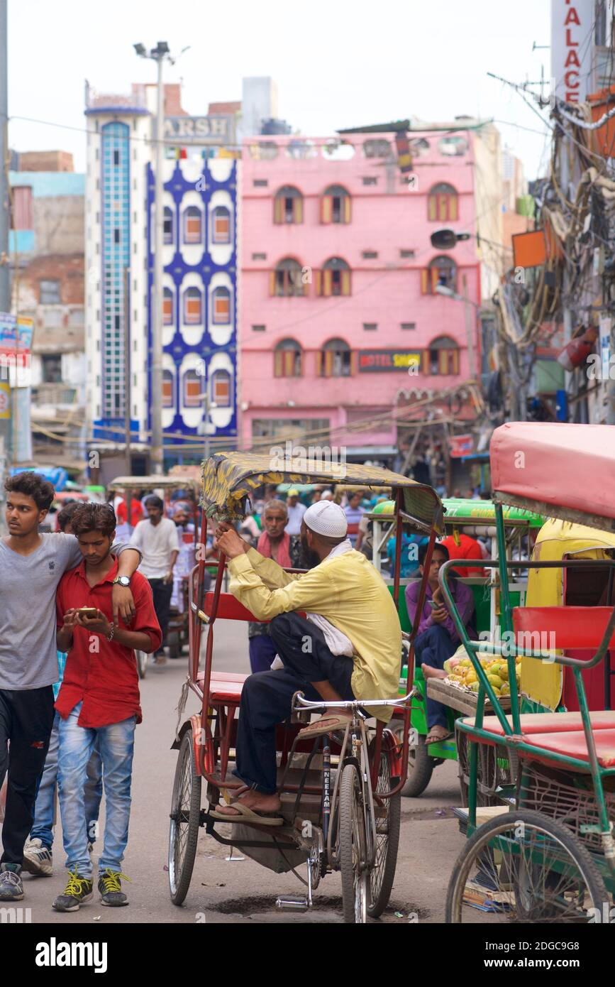 Indian rickshaw driver waiting for business in a busy street, Old Delhi ...