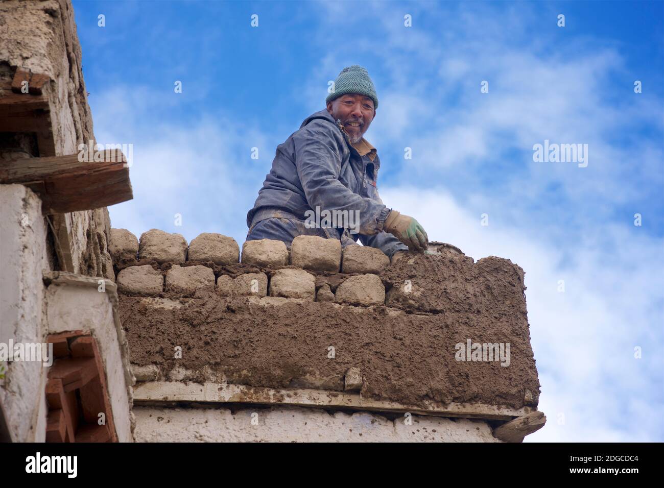 Ladakhi house builder constructing a wall in Ladakhi local style with ...
