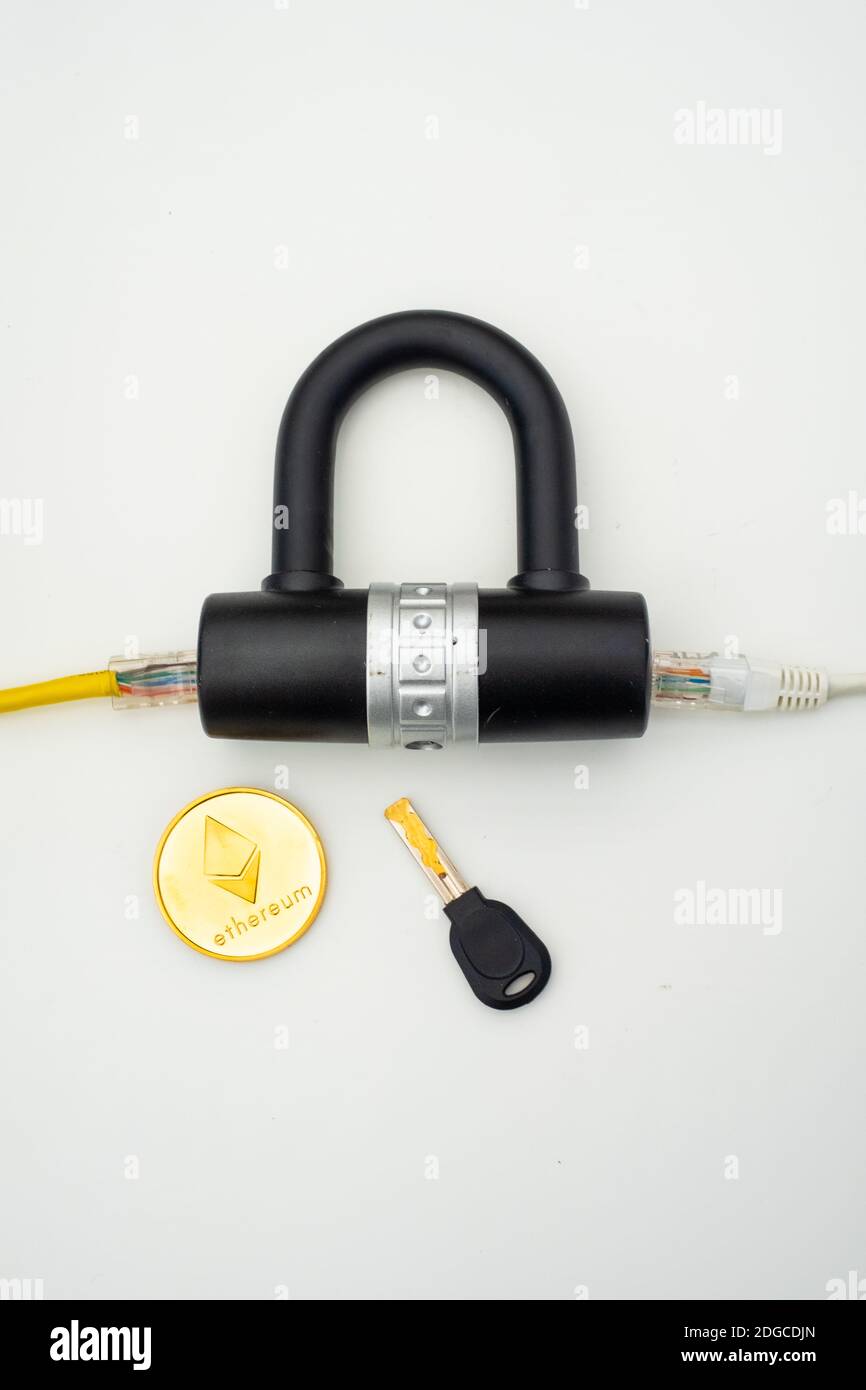 Two computer network cables going through a lock with a key and a ...