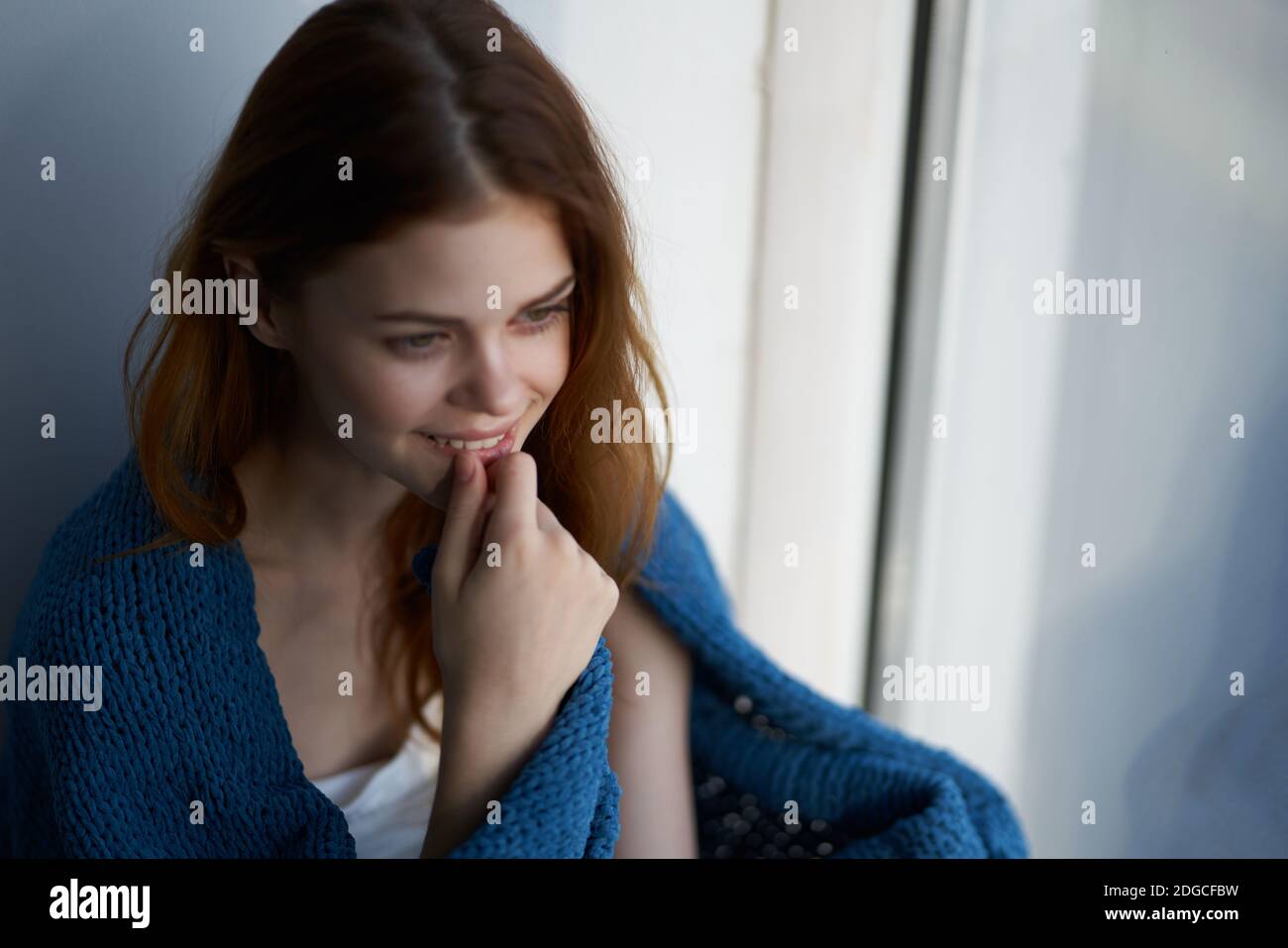 pretty woman near the window hiding with a blanket fun weekend vacation ...